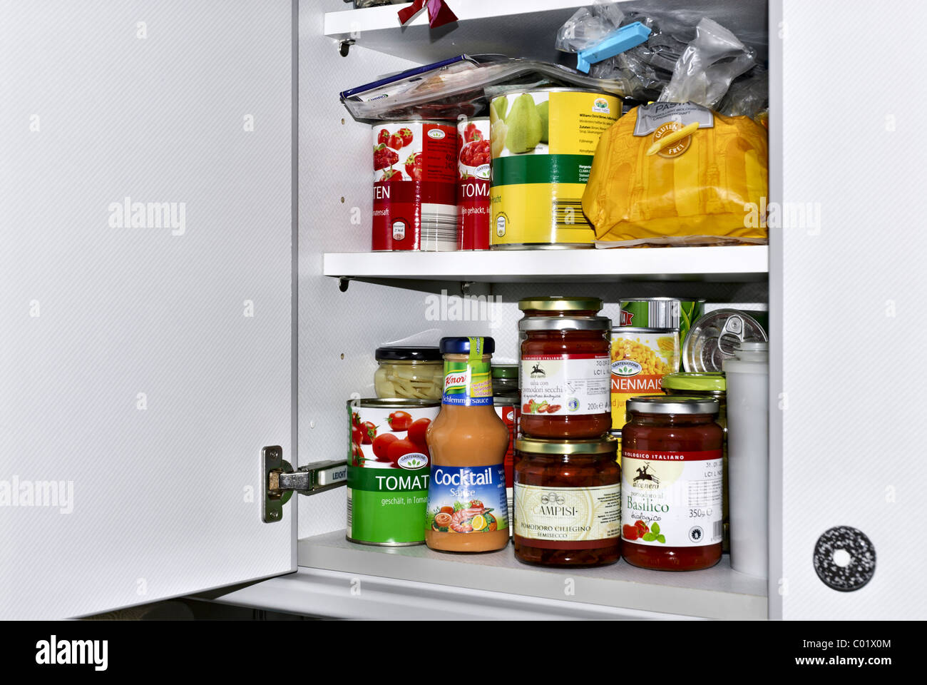 Kitchen cabinet with an assortment of food products in shelves Stock ...