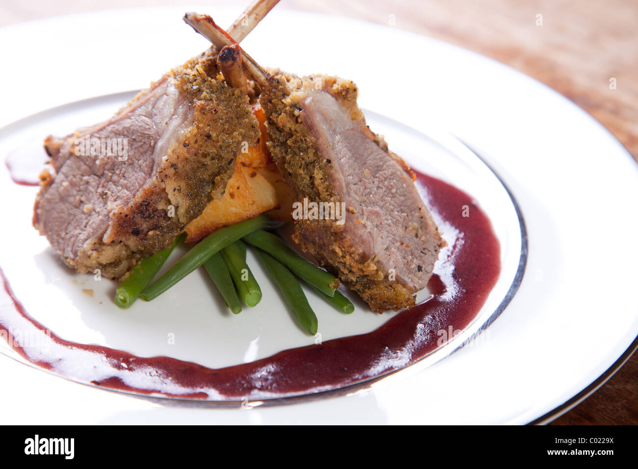 Rack of lamb with vegetables on wooden table Stock Photo - Alamy
