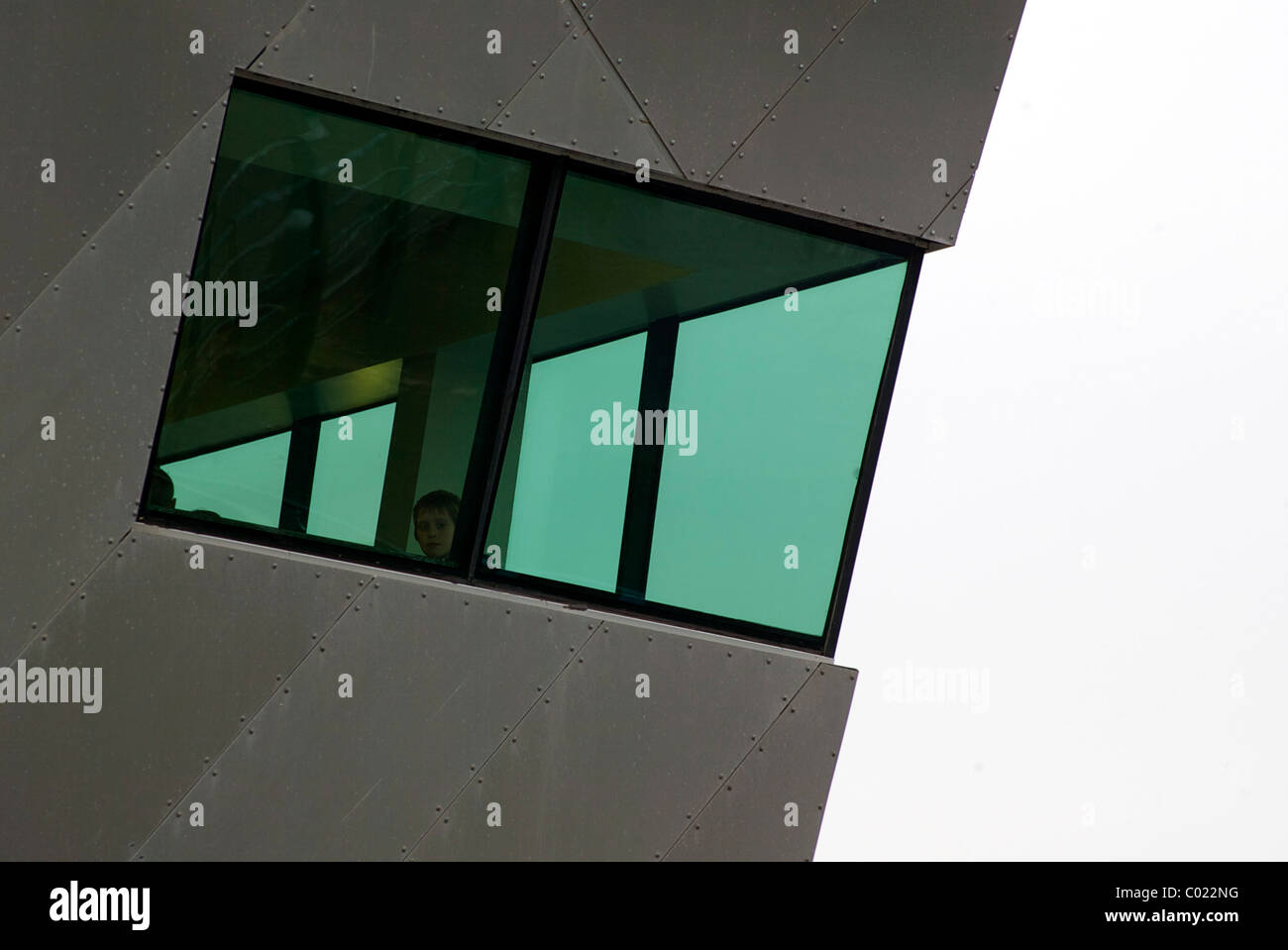 A Young boy looking out of a window of the Imperial War Museum North ...