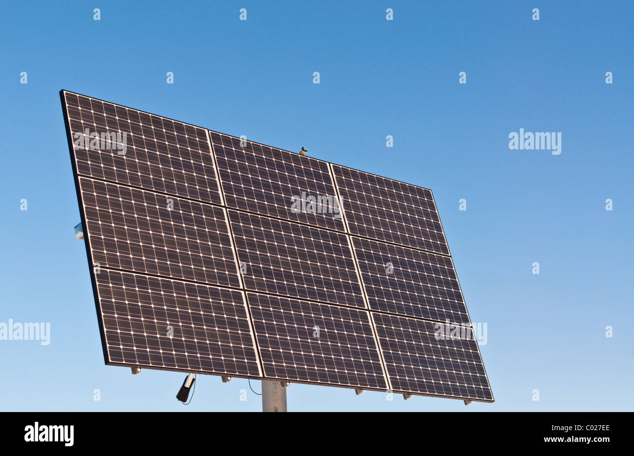 Photovoltaic solar panel array with a clear blue sky in the background ...