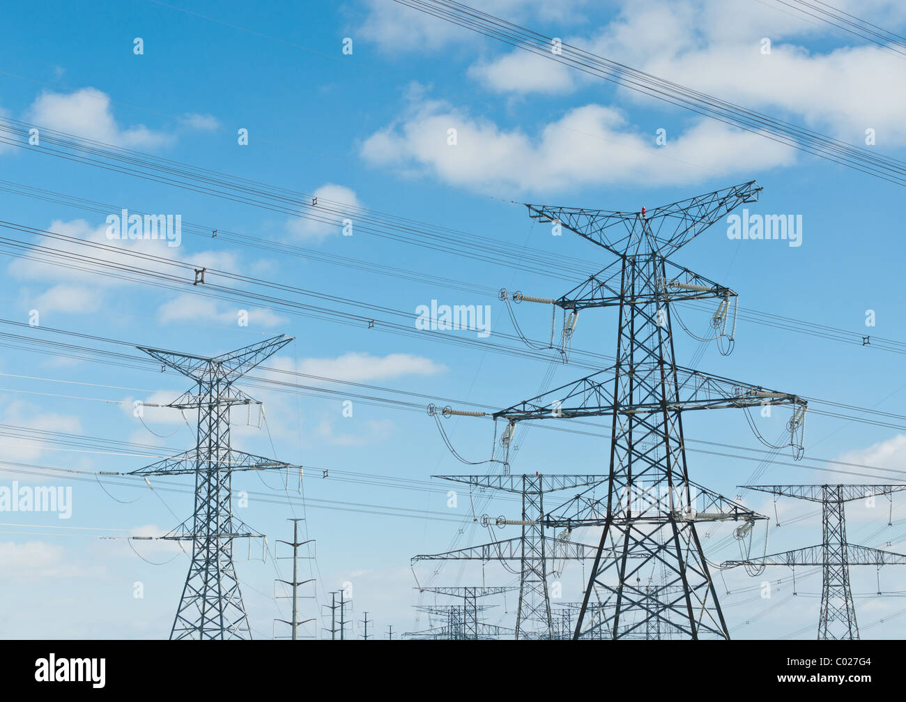 A long line of electrical transmission towers carrying high voltage ...
