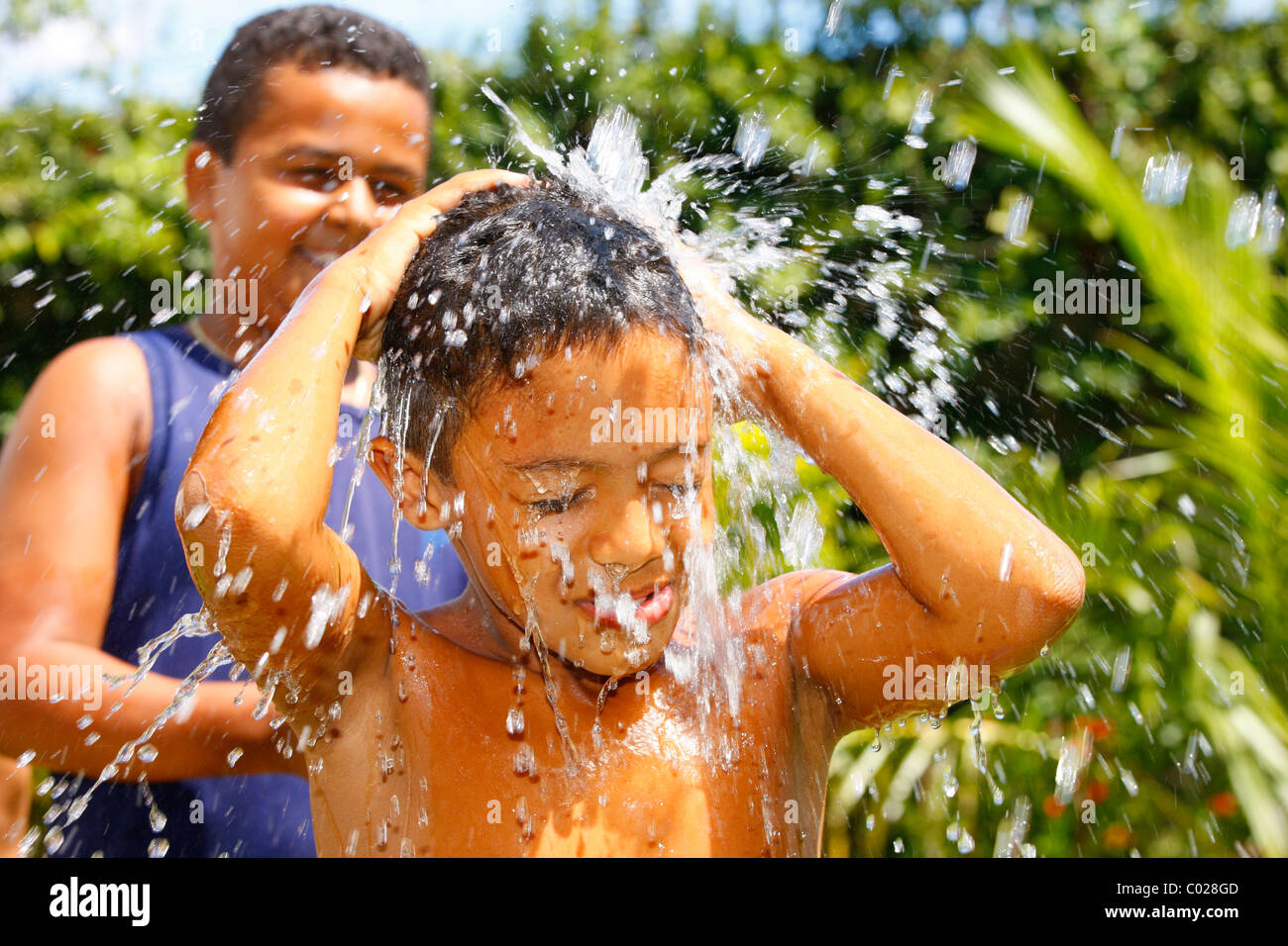 Boy being sprayed with a water hose, Fortaleza, Ceará, Brazil, South ...