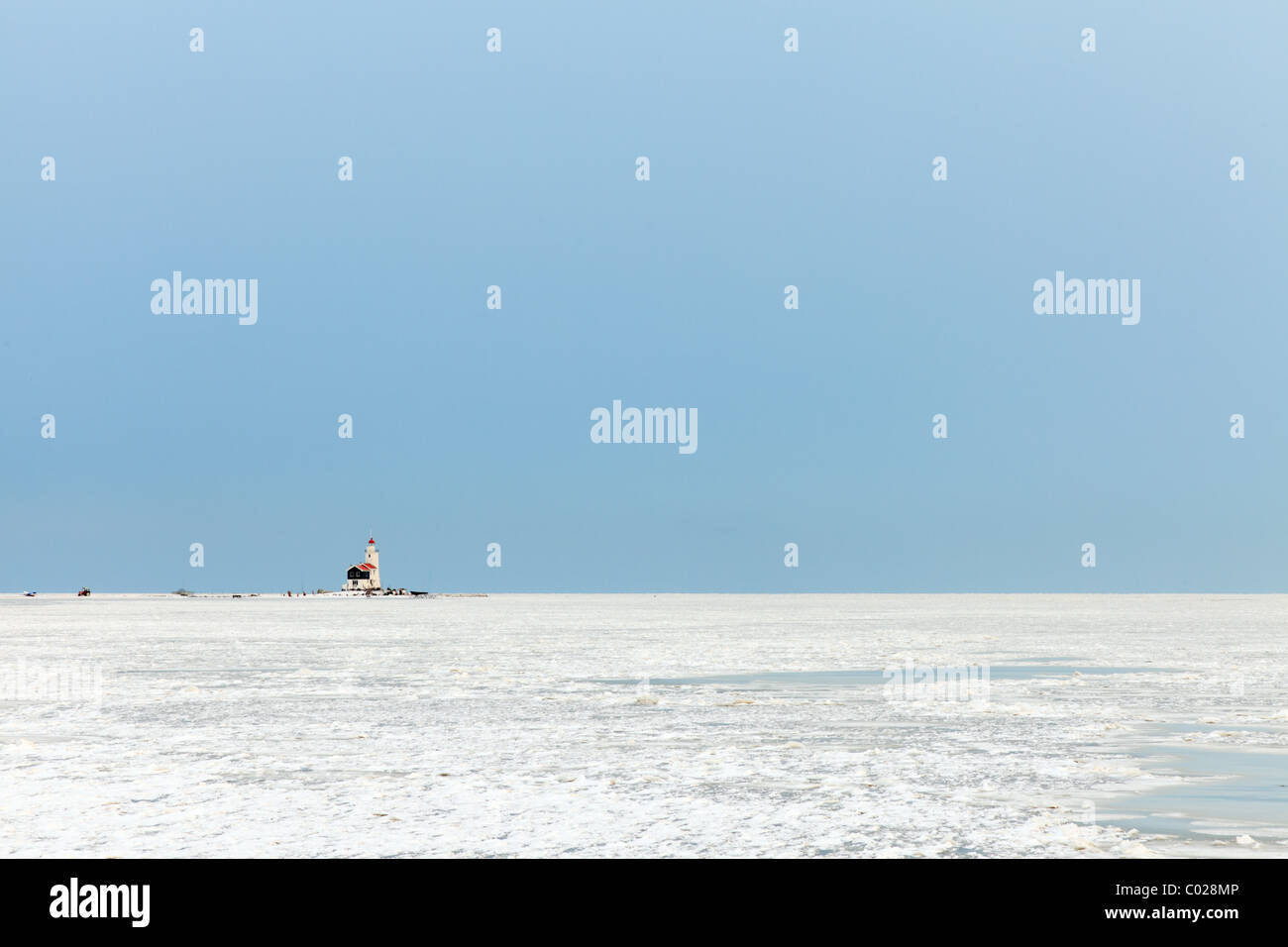 Frozen sea with lighthouse at sunset Stock Photo - Alamy