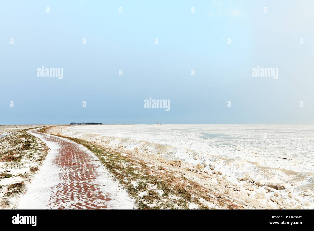 Old Dutch village in winter with dike and frozen sea at sunset Stock ...