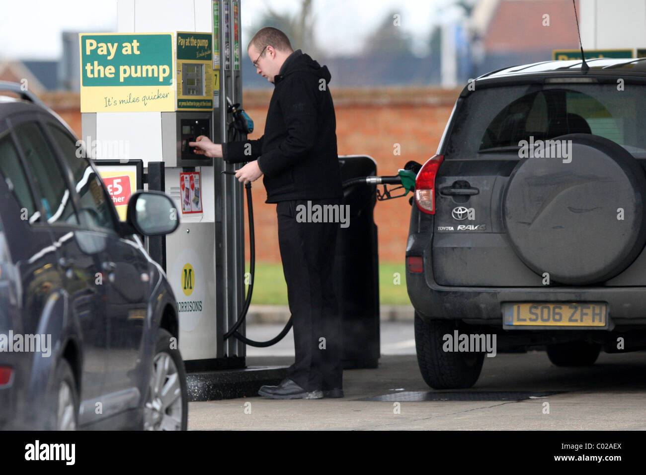 PEOPLE FILLING UP CARS AT PETROL STATION Stock Photo - Alamy