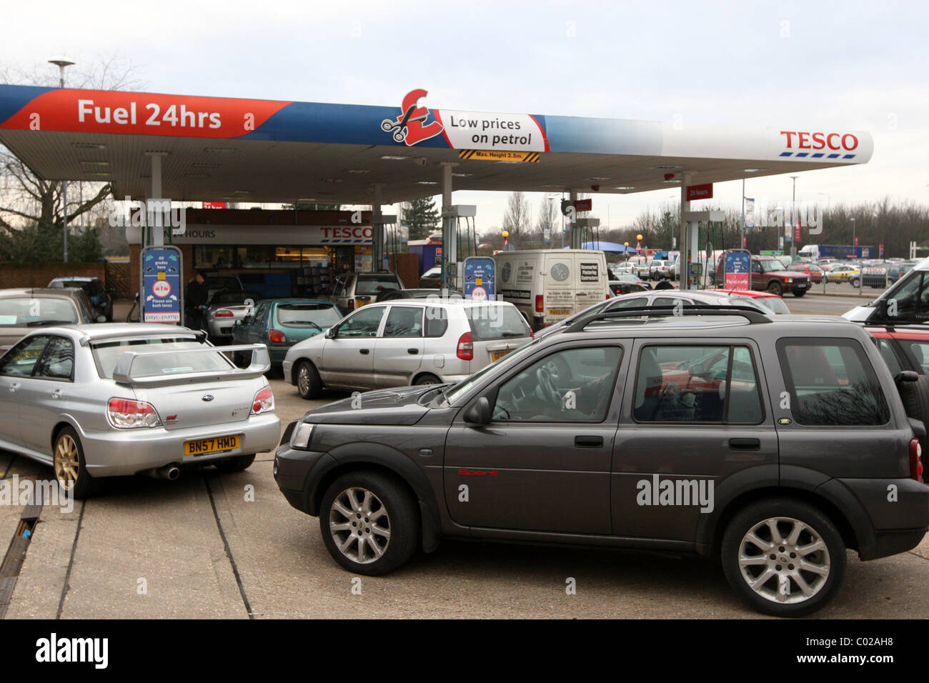 PEOPLE FILLING UP CARS AT PETROL STATION Stock Photo - Alamy