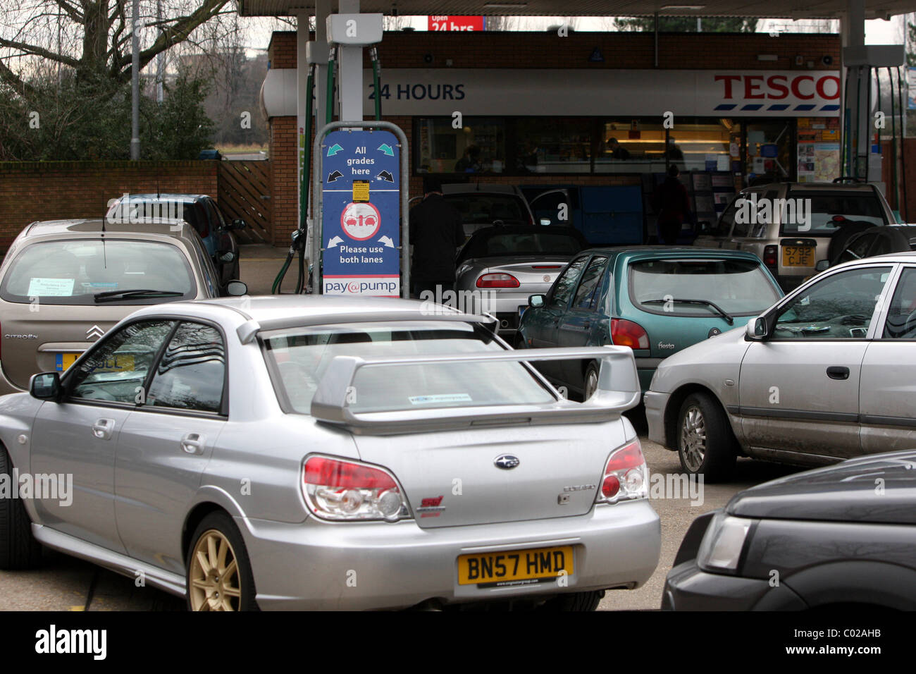 PEOPLE FILLING UP CARS AT PETROL STATION Stock Photo - Alamy
