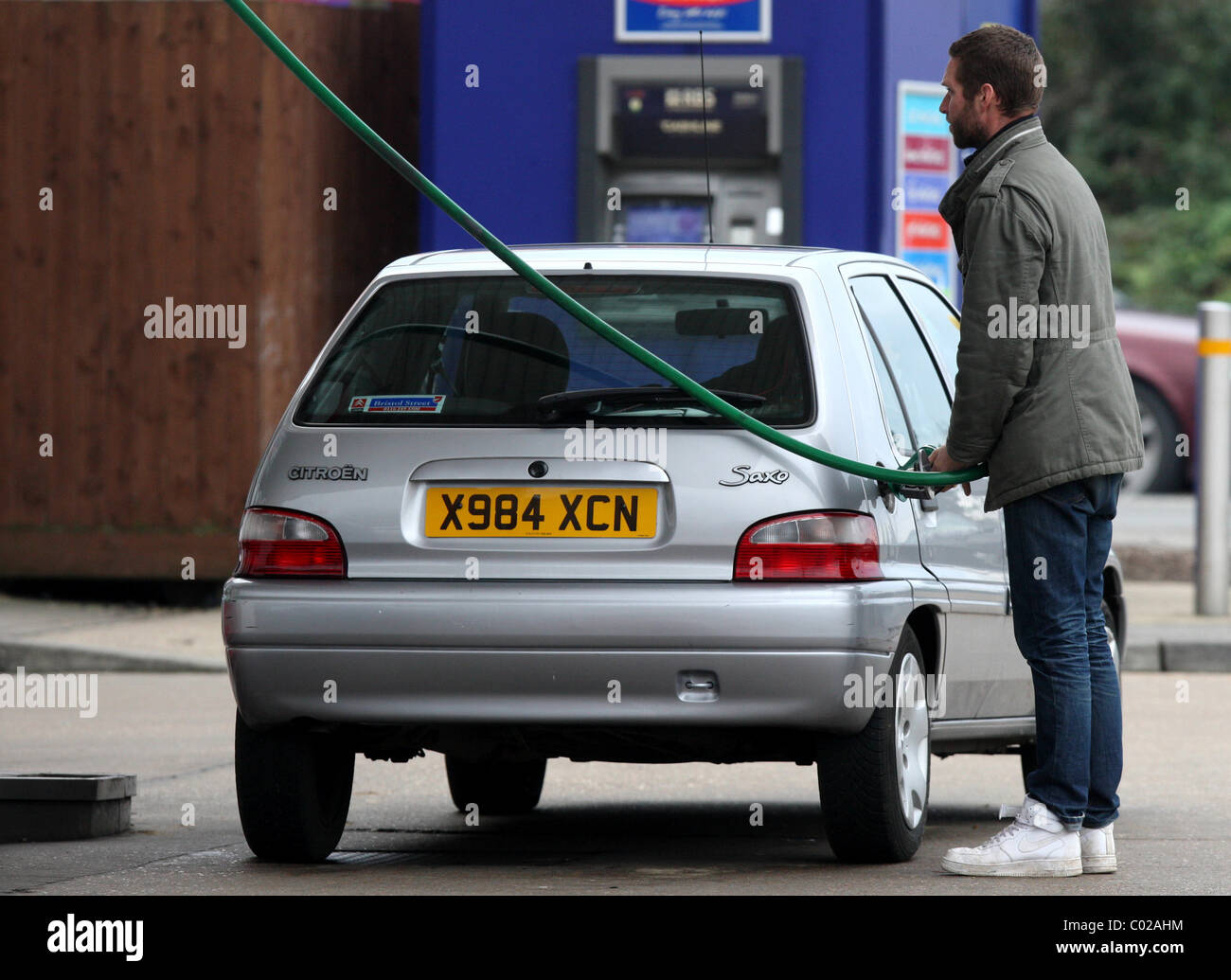 PEOPLE FILLING UP CARS AT PETROL STATION Stock Photo - Alamy