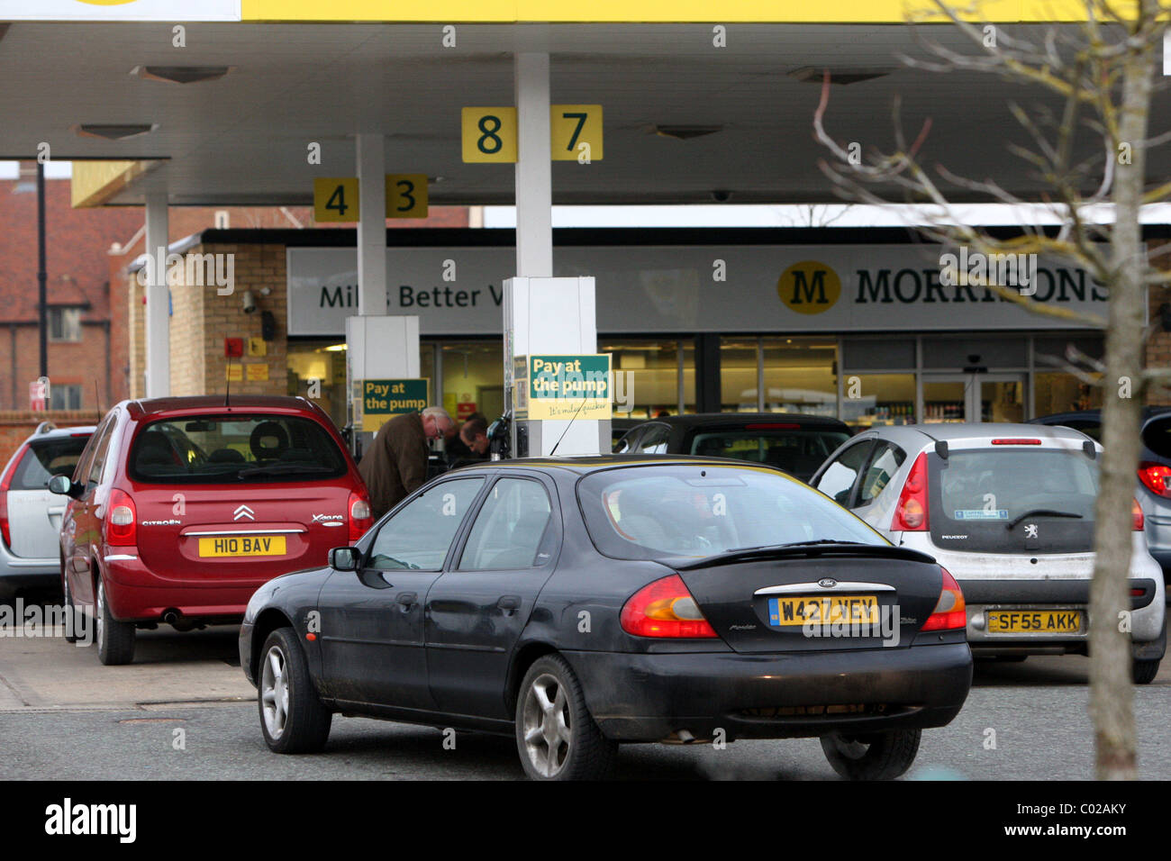 PEOPLE FILLING UP CARS AT PETROL STATION Stock Photo - Alamy