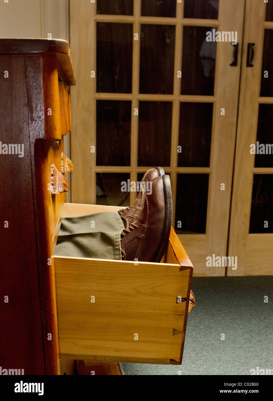 man's legs and shoes lying down in open dresser drawer Stock Photo - Alamy