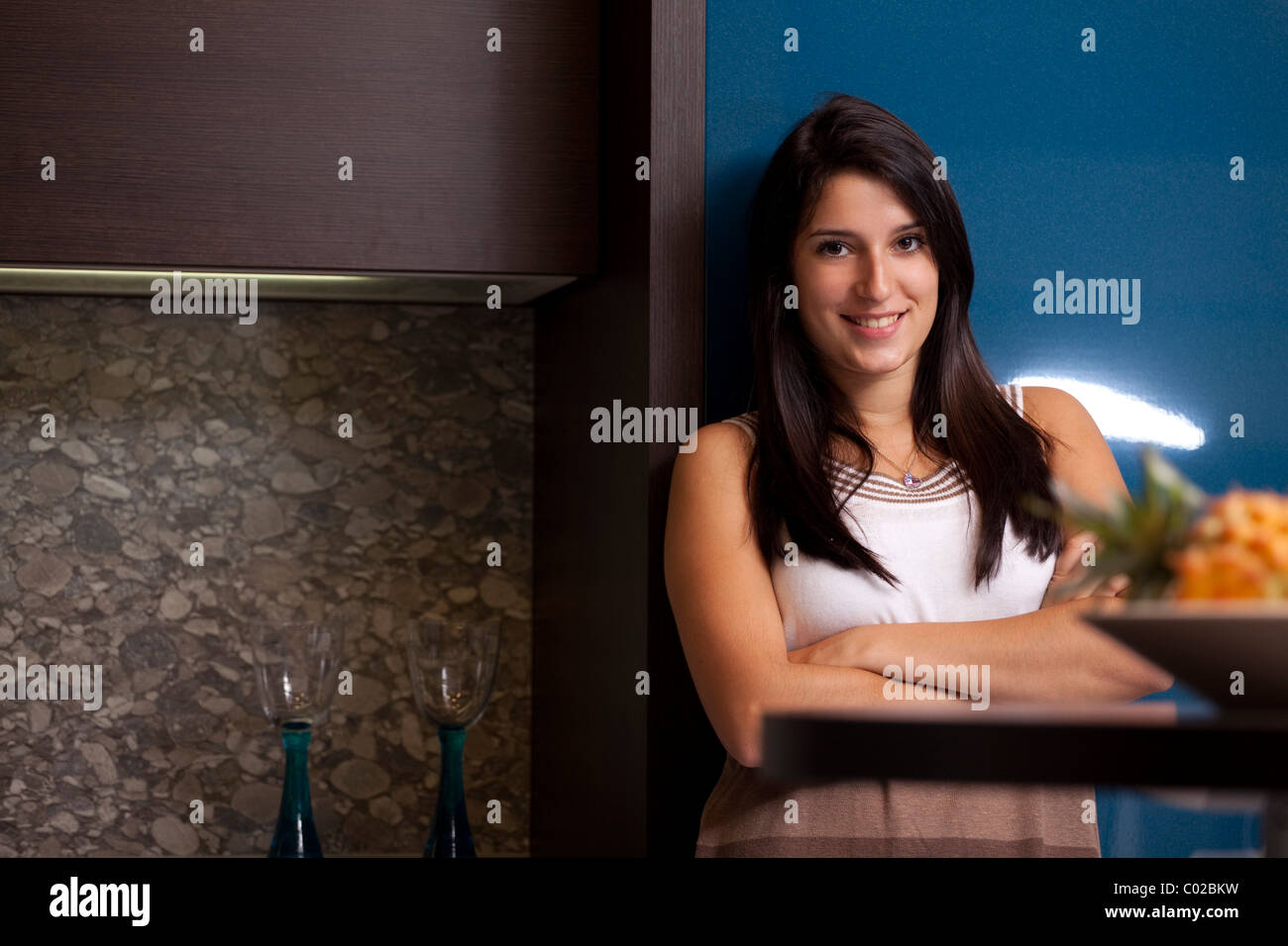 Young woman standing in the kitchen and relaxing Stock Photo - Alamy