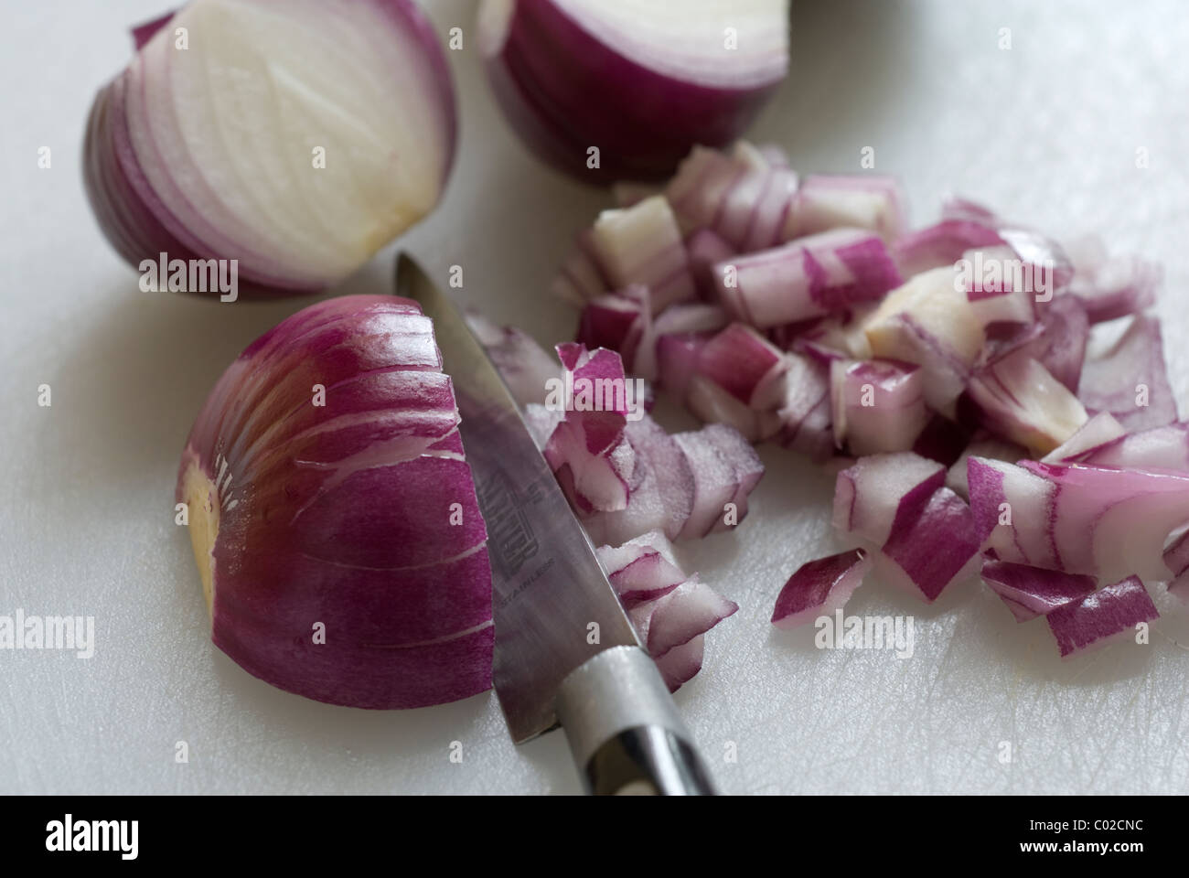 Chopping red onions on a white chopping board Stock Photo - Alamy