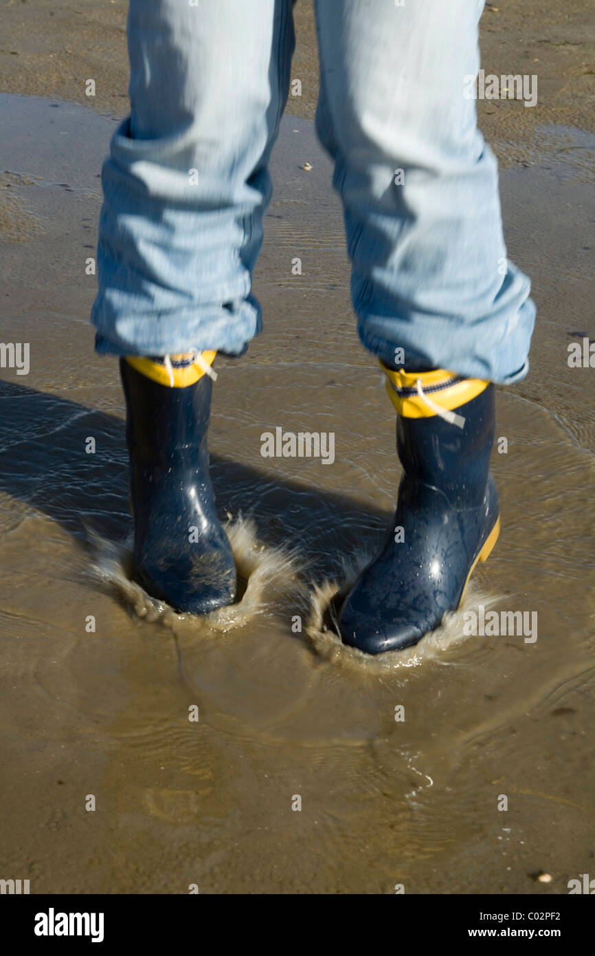 Jumping in a puddle with rubber boots Stock Photo - Alamy