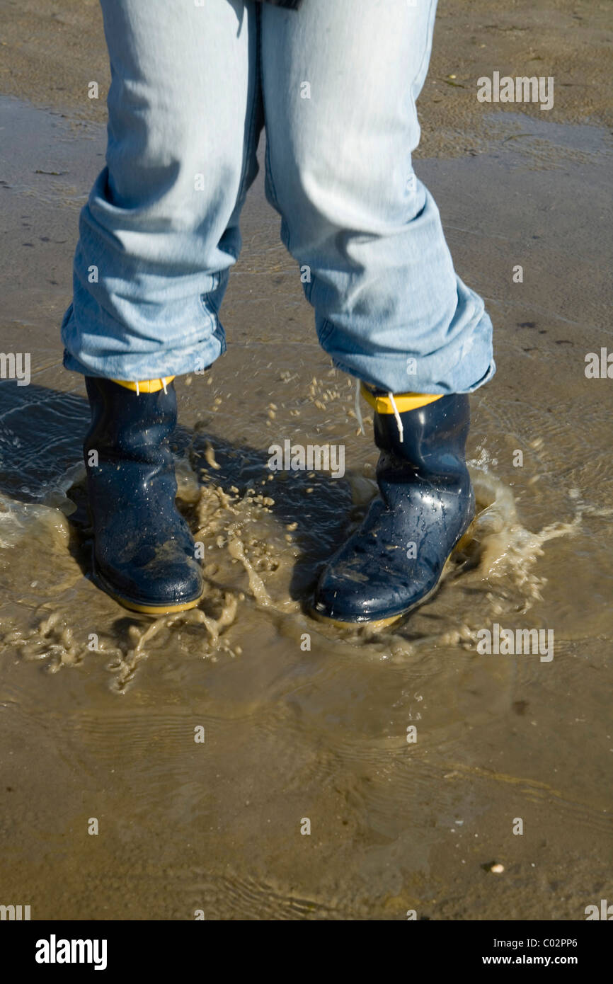 Jumping in a puddle with rubber boots Stock Photo - Alamy