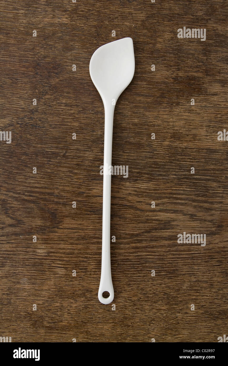 White spoon on a wooden table Stock Photo - Alamy