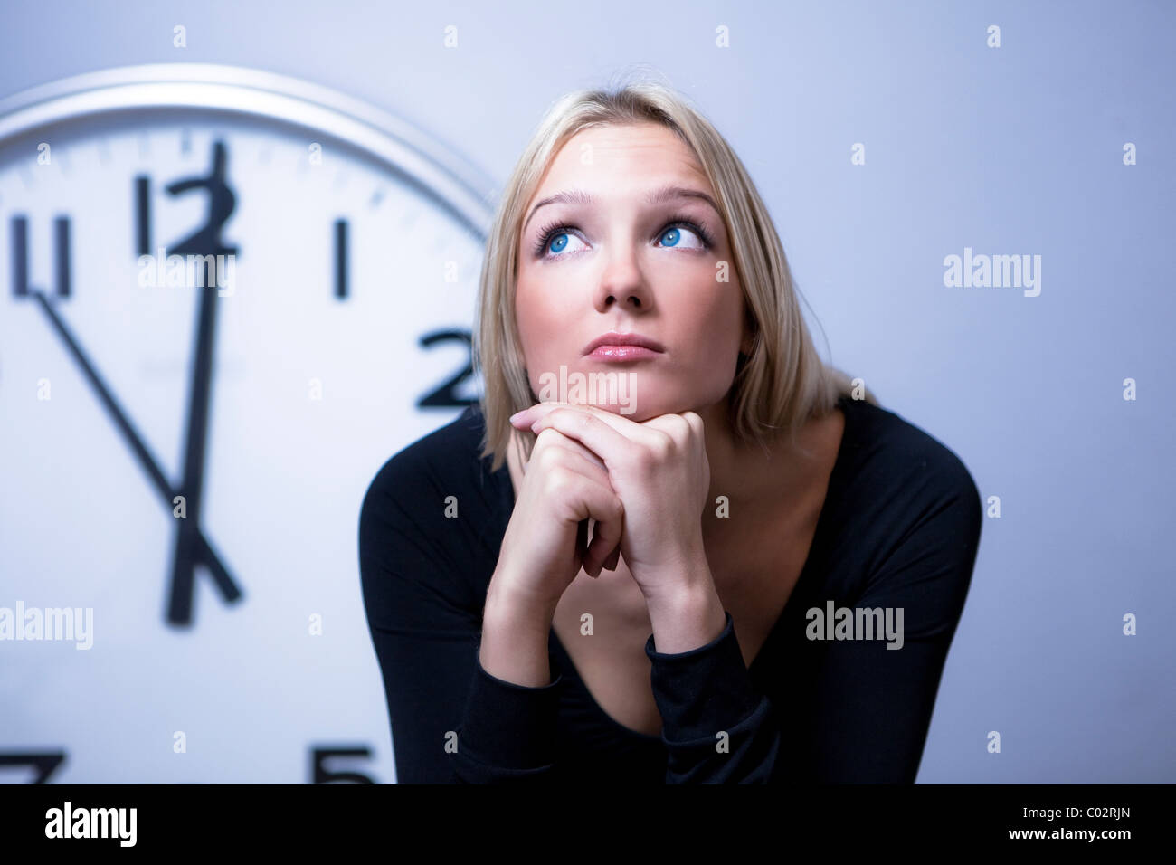 bored woman with a big clock on the wall Stock Photo - Alamy