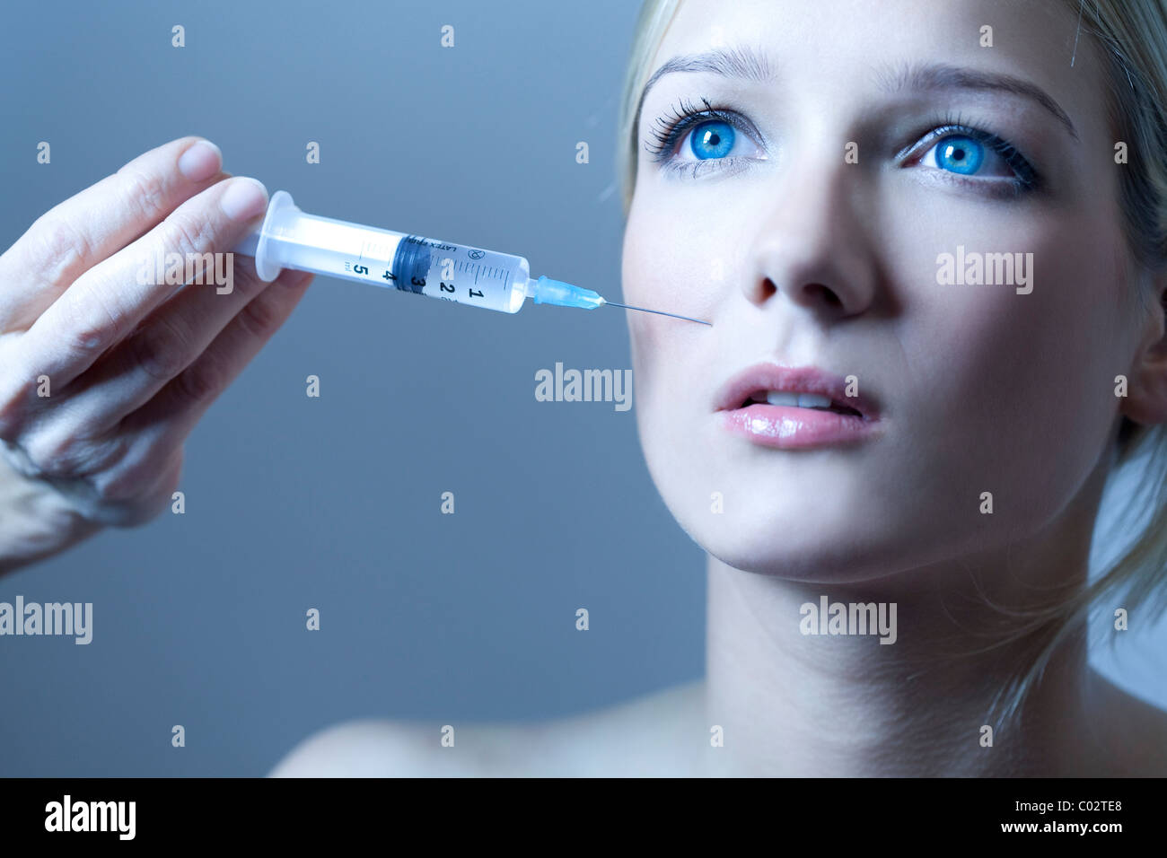 Close-up of woman with a syringe on face Stock Photo - Alamy