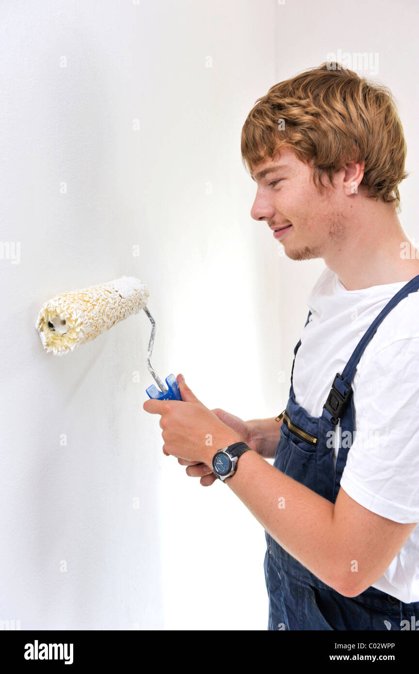 Young man painting wall Stock Photo - Alamy