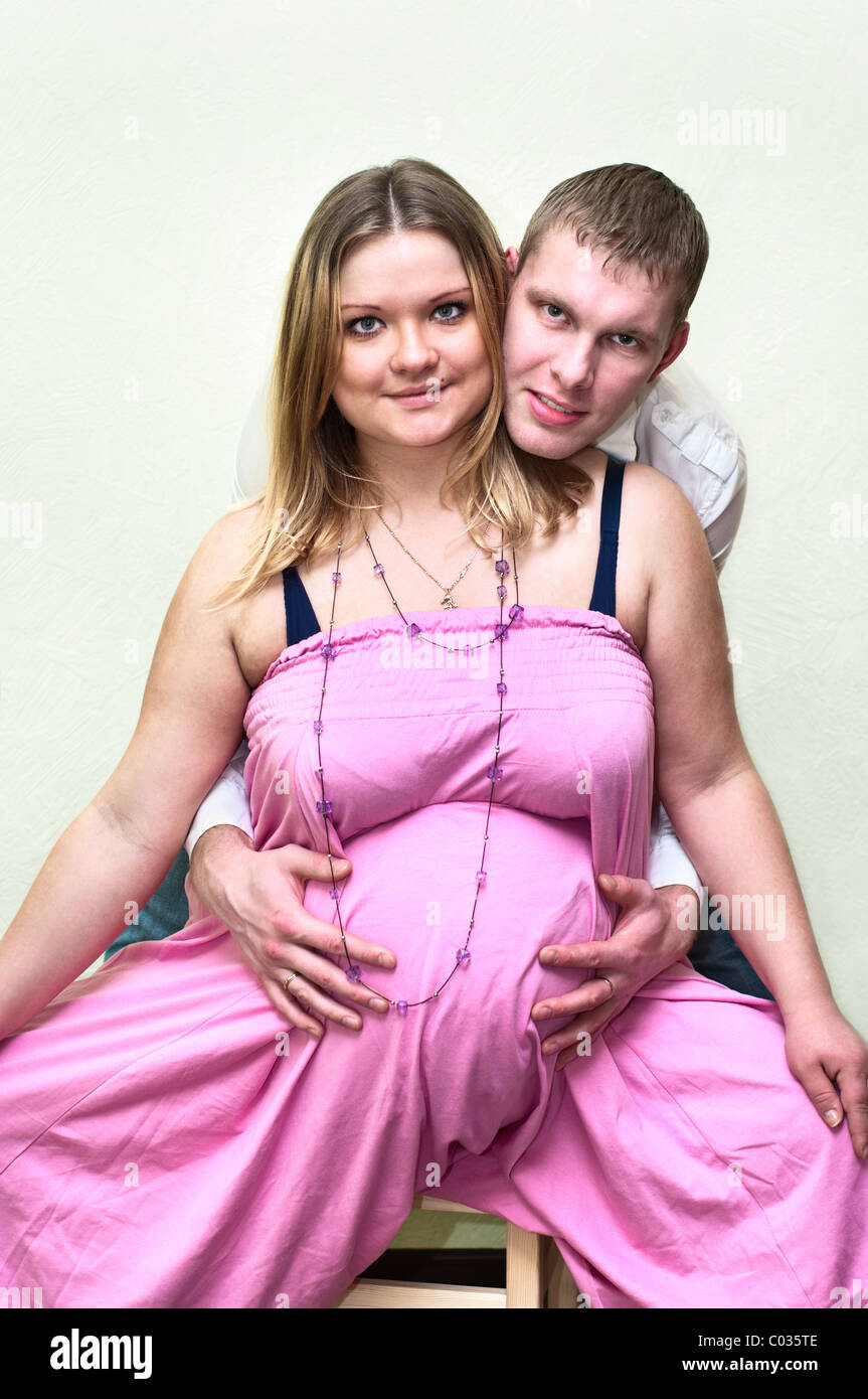Pregnant Woman With Her Husband Sitting On Chair Caucasians A Loving