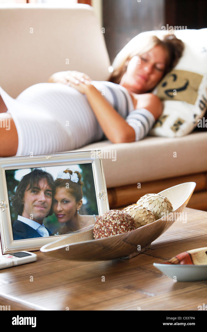 pregnant woman laying down with wedding picture on the table Stock ...