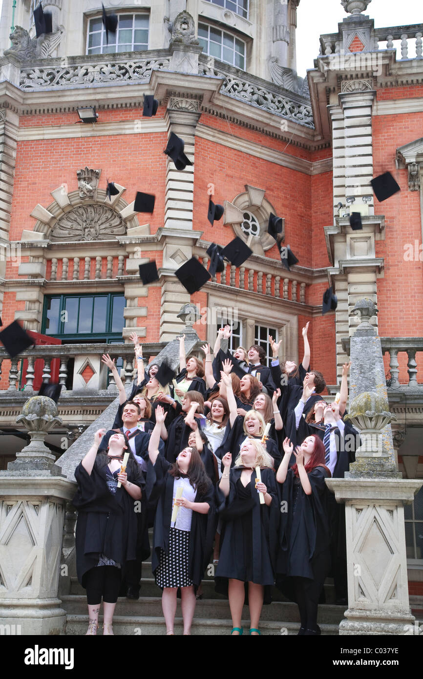 Graduating students throw their mortar boards in the air at a ...