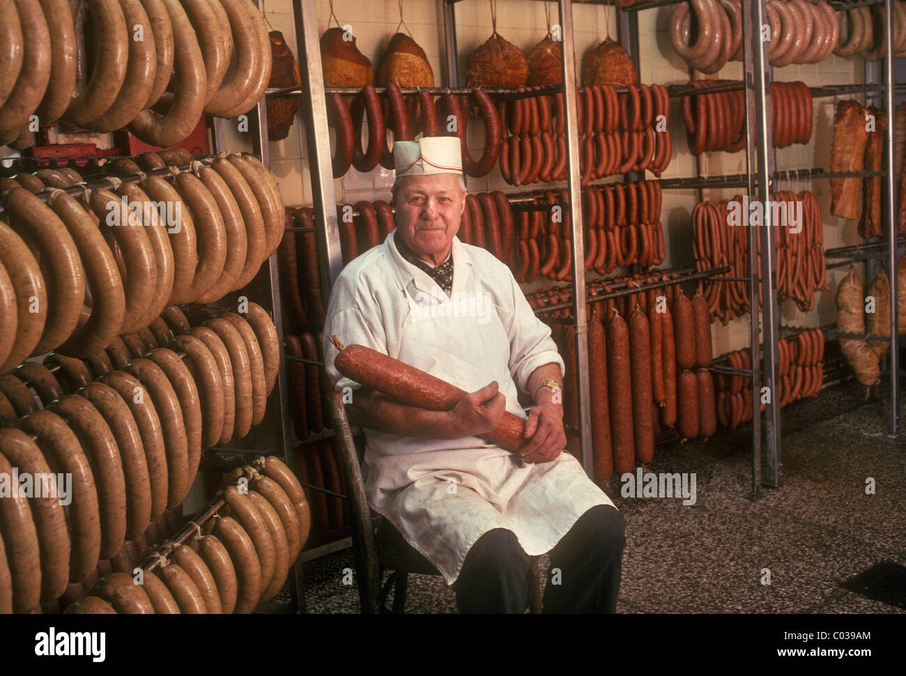 Butcher with kielbasa, sausage and hams Stock Photo - Alamy