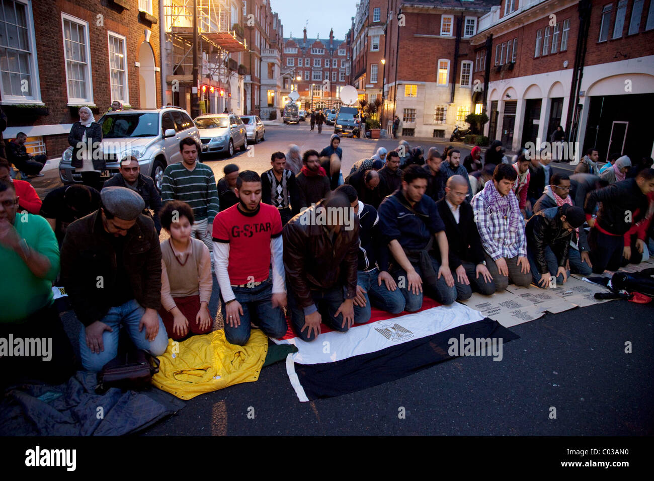 Protesters praying in London after announcement that their President ...