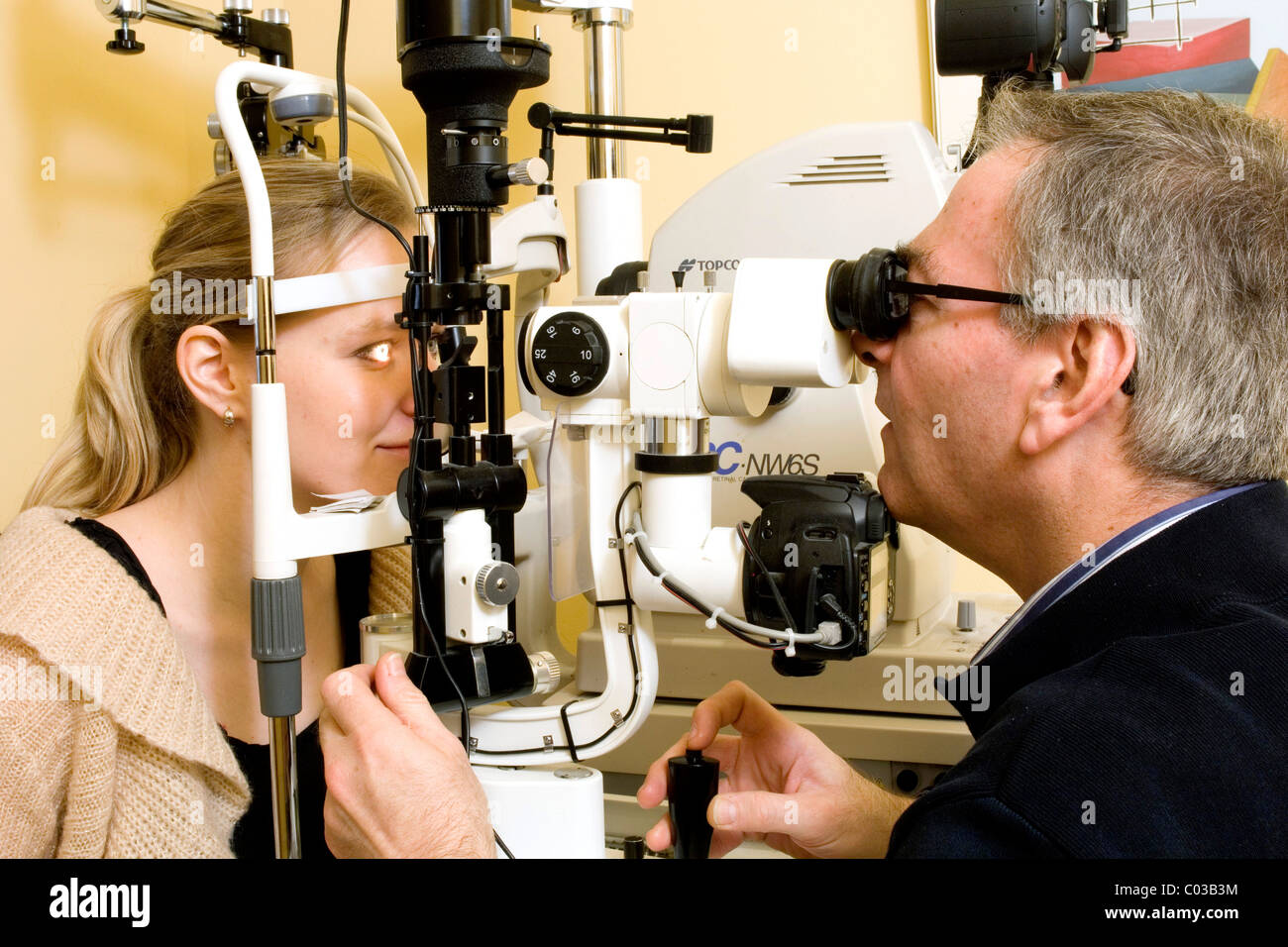 Female patient has an eye test using slit lamp equipment Stock Photo ...