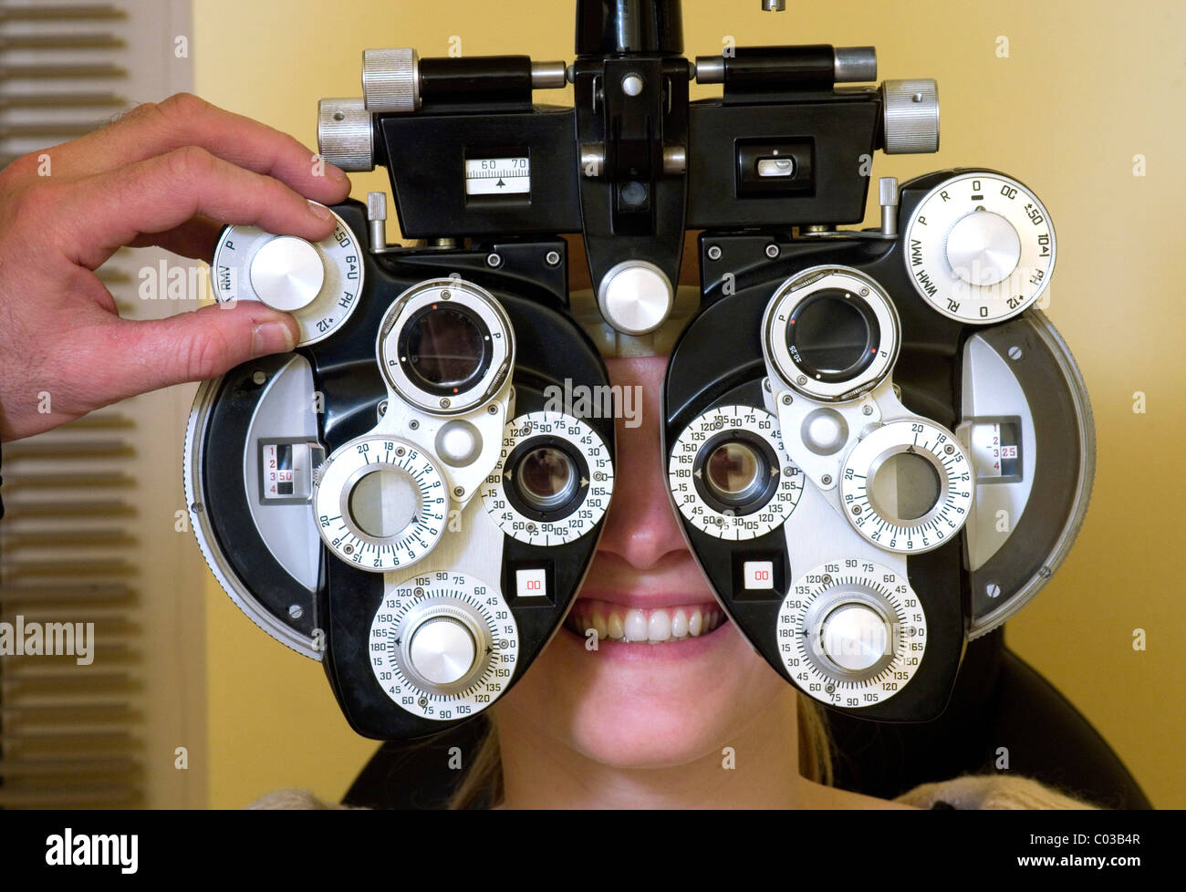 Female patient has an eye test using a Refractor Stock Photo - Alamy