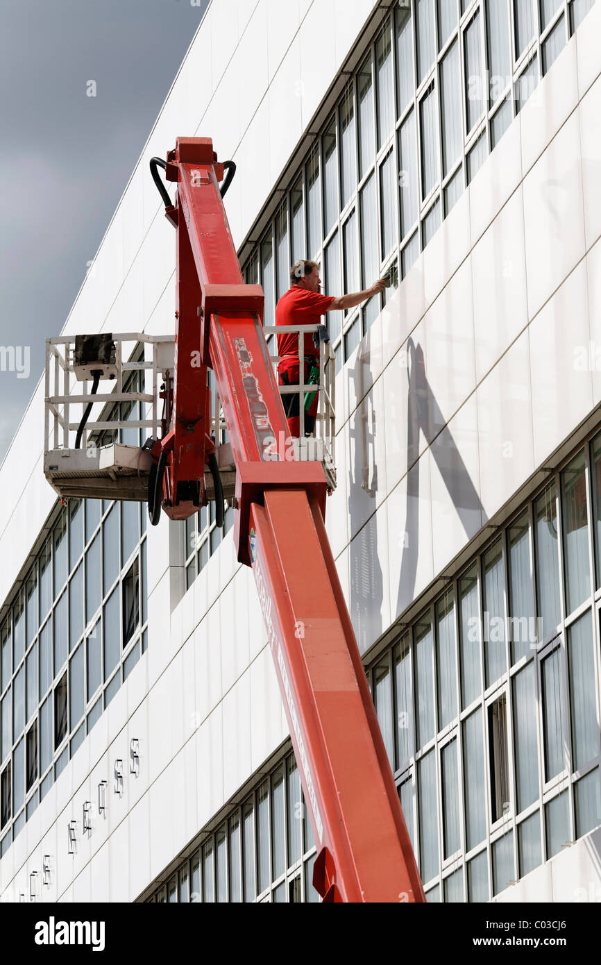 Building cleaner on a boom lift cleaning the windows of Neuss ...