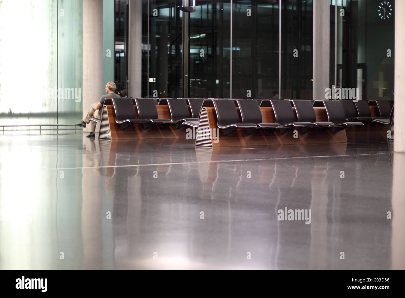 Single male sat in waiting area in Zurich airport Stock Photo - Alamy