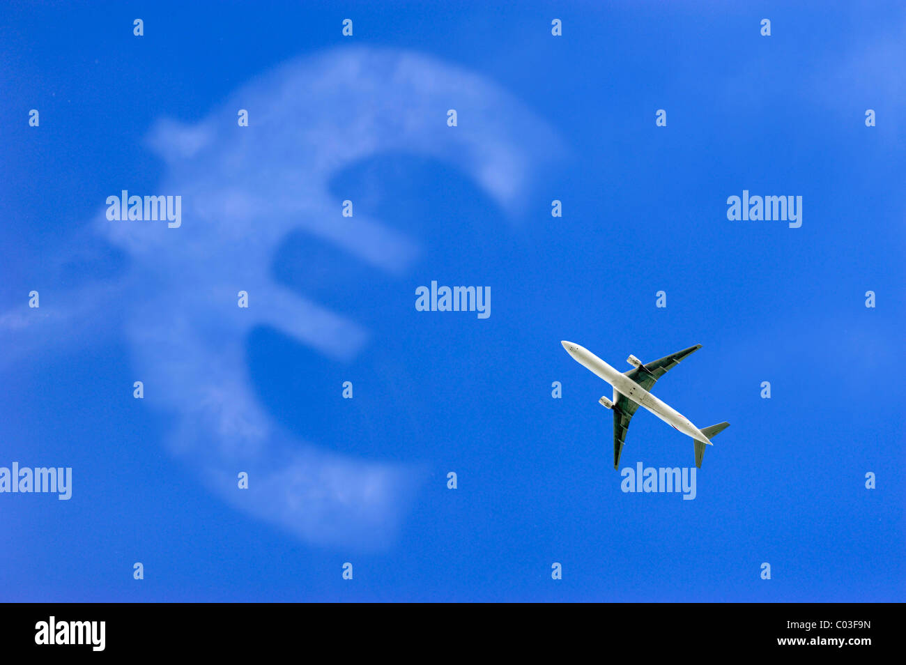 Aircraft flying against a blue sky with a Euro sign, symbolic image for ...