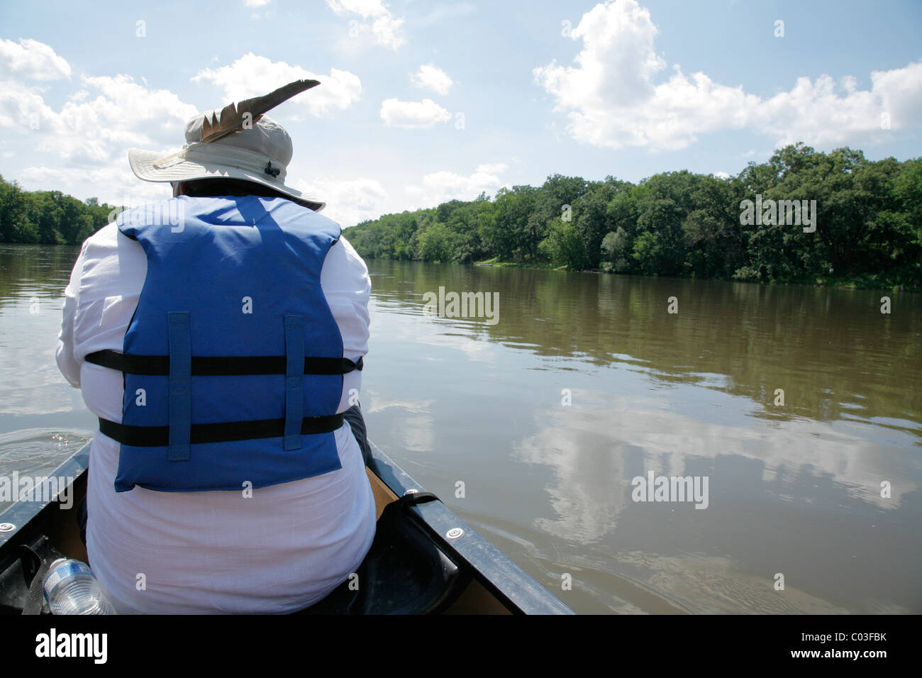 Back view of a man in the front of a canoe paddling on the Fox River ...