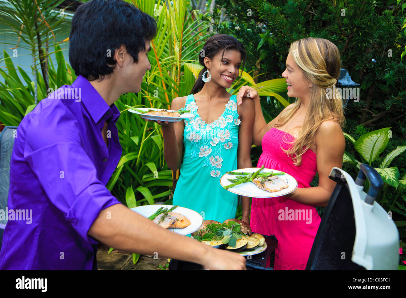 three friends at a barbecue party in hawaii Stock Photo - Alamy