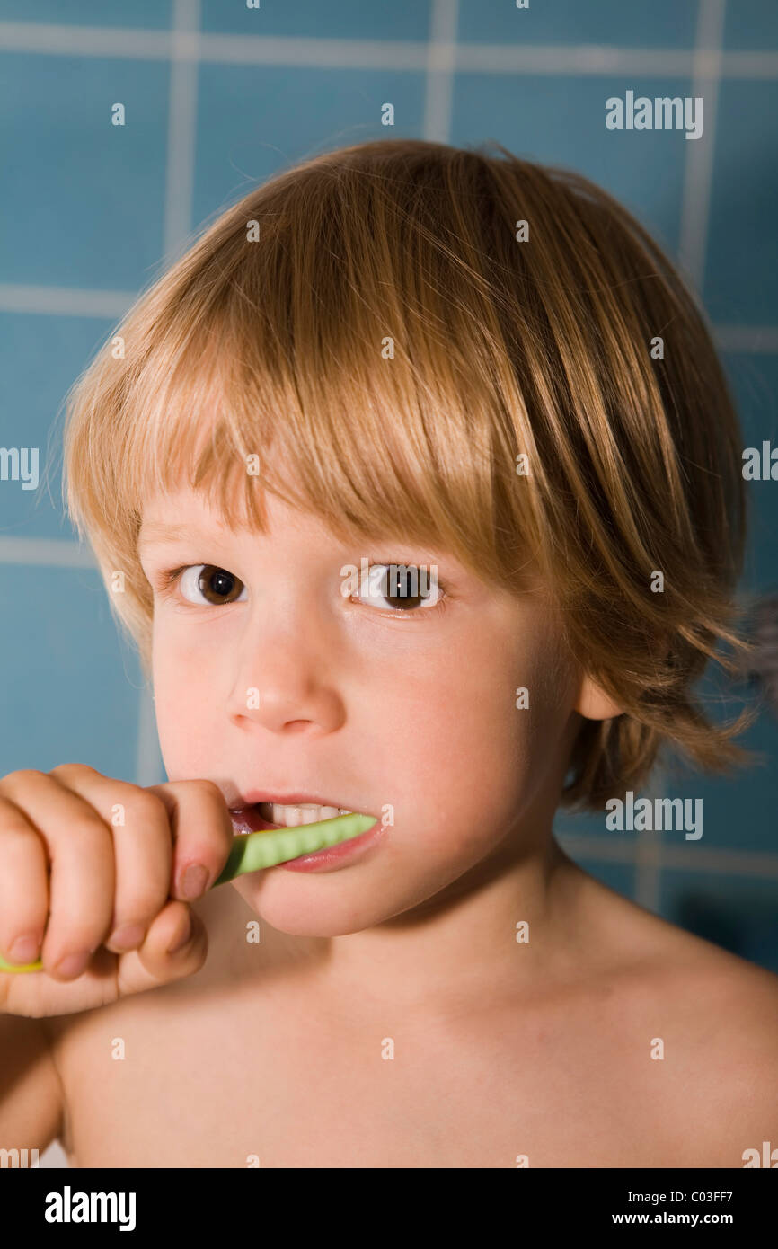 Four-year-old blond boy brushing his teeth Stock Photo - Alamy
