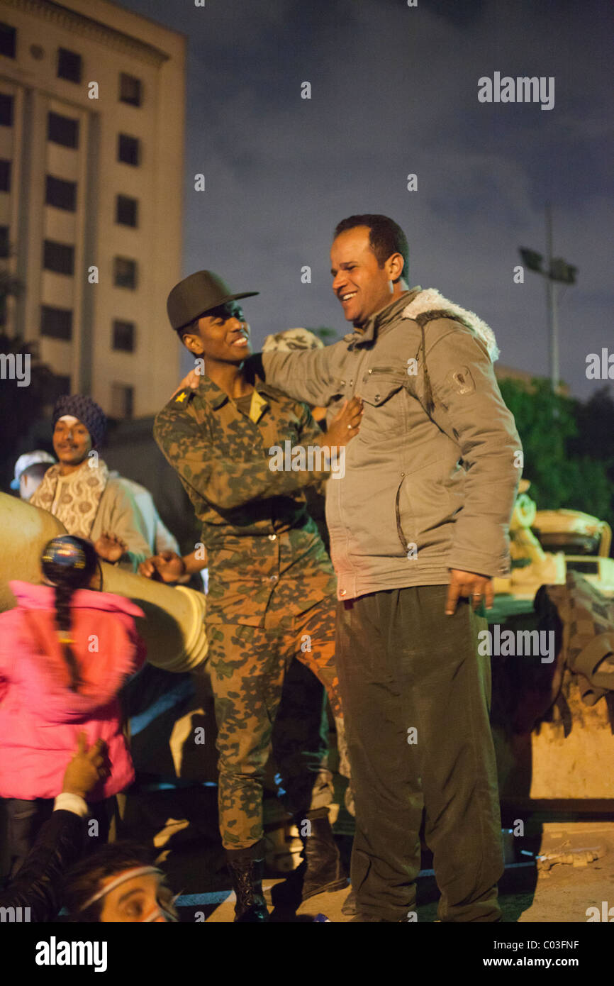 Egyptian civilian and army soldier embracing on top of tank, Tahrir ...