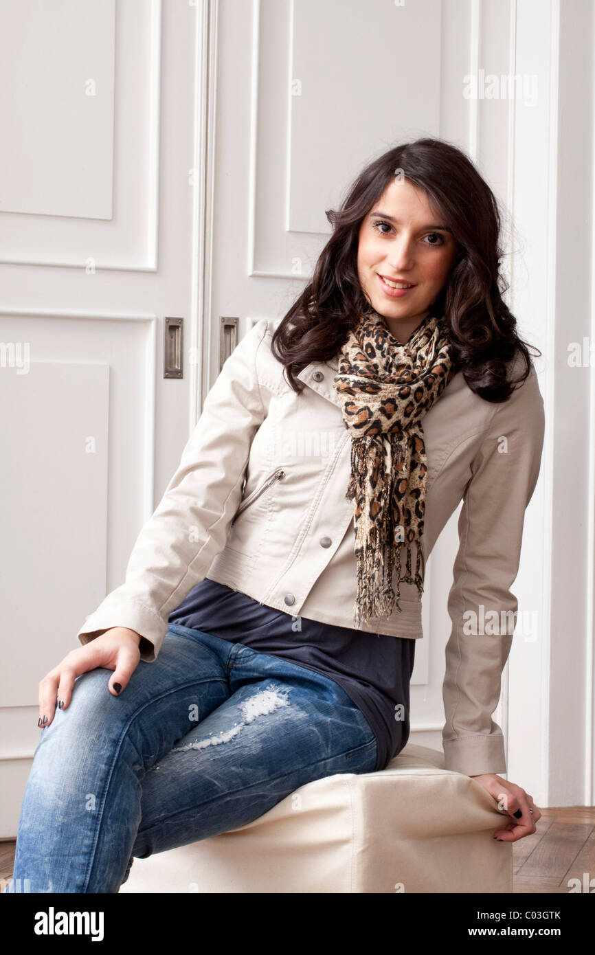 Young woman sitting on a stool Stock Photo - Alamy