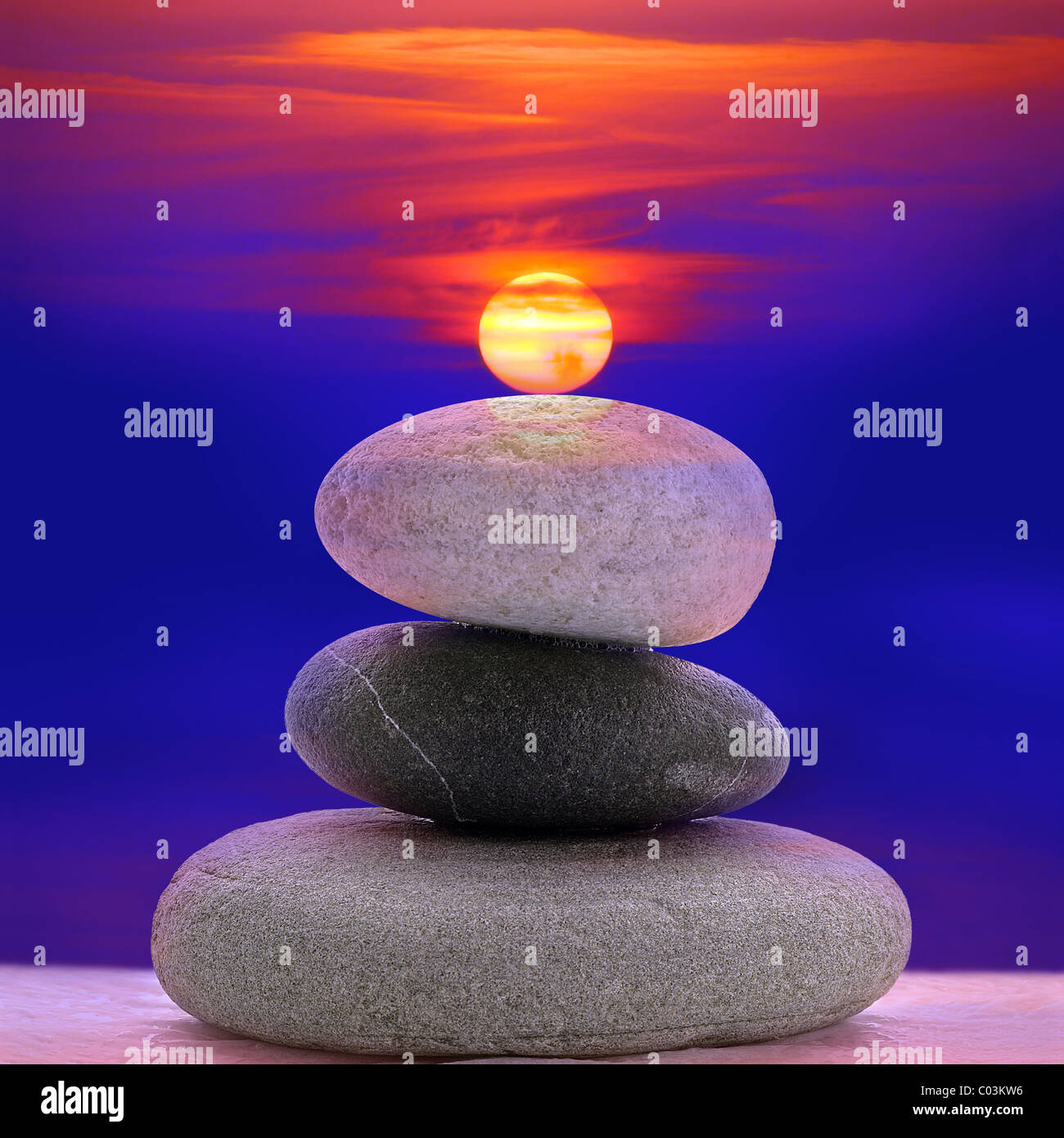balanced stones with sunset background to appear that sun is resting on ...