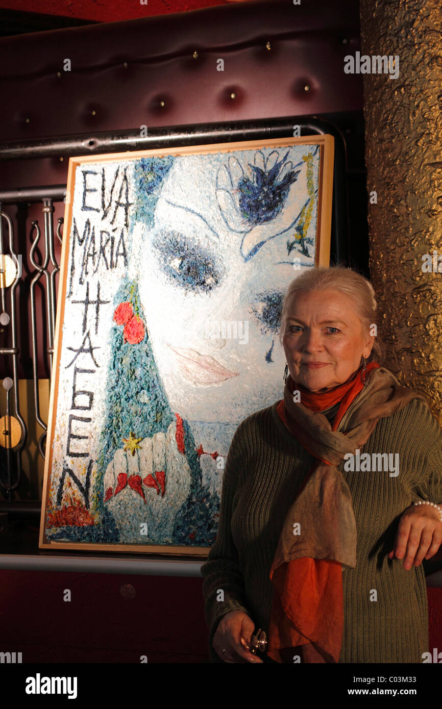 Actress, singer and painter Eva-Maria Hagen standing in front of one of ...