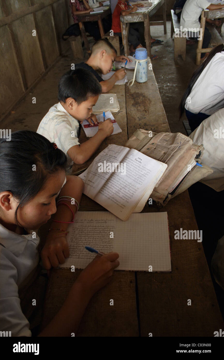 A group of students are studying at their desks in rundown classroom ...
