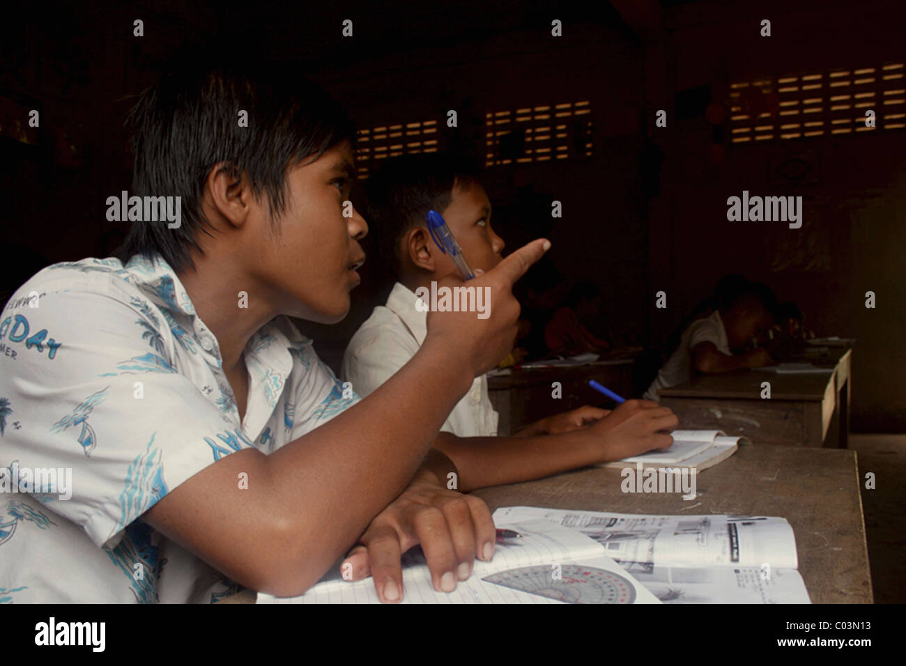 A young boy who is a school student is pointing during an English ...