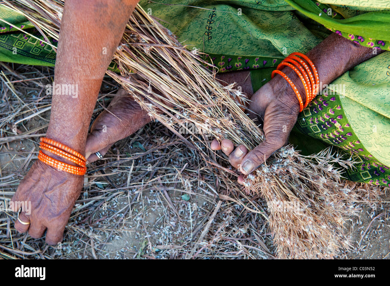 Old indian womans hands working with grass making sweeping brushes ...