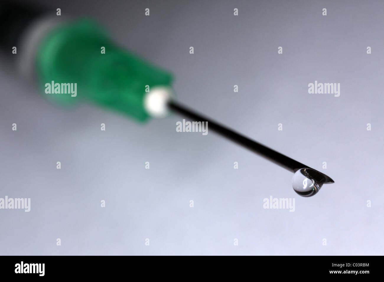 Syringe and needle with drop of clear liquid Stock Photo - Alamy