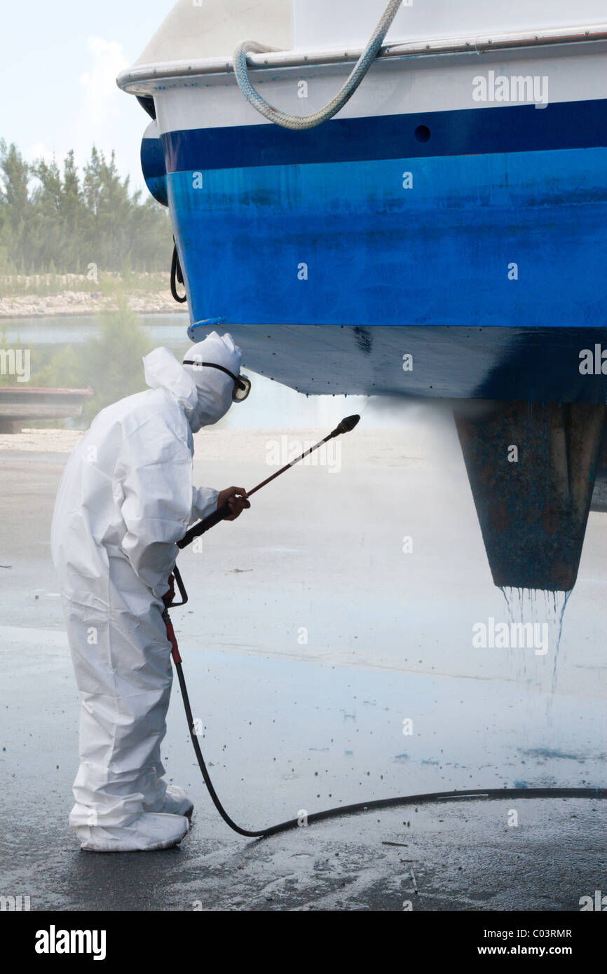 A man pressure washes the hull of a boat Stock Photo - Alamy