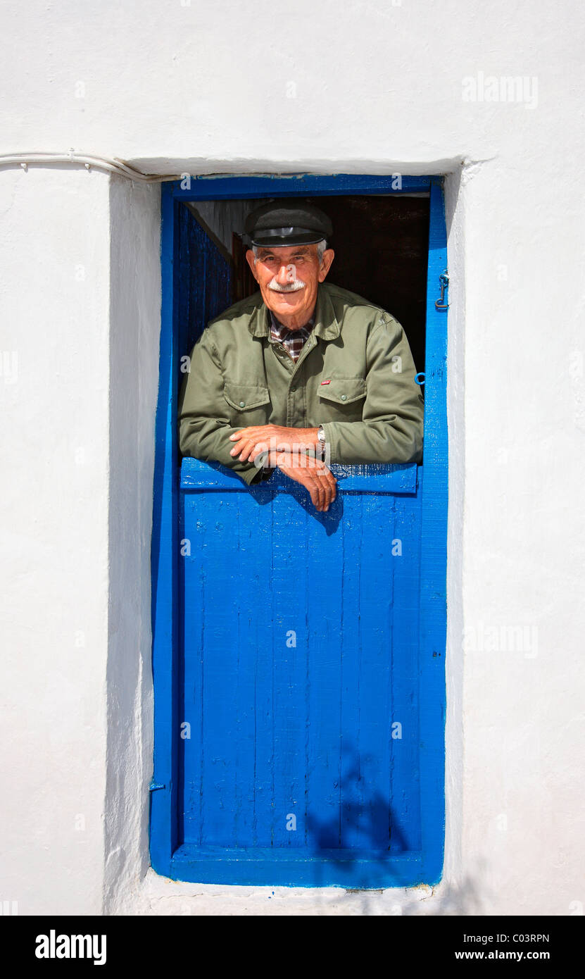 An old Greek man smiling from the door of his house in Ano Mera village ...