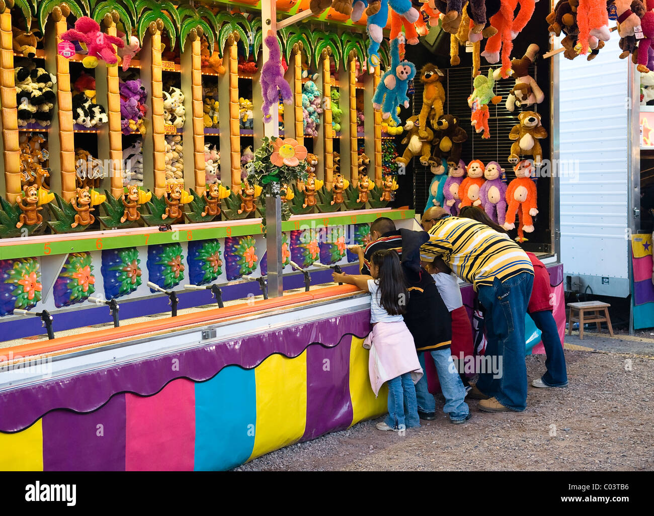Family plays shooting game at county fair group concentration hi-res ...