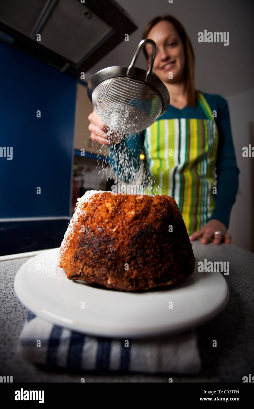 young cheffe dusting sugar on a cake Stock Photo - Alamy