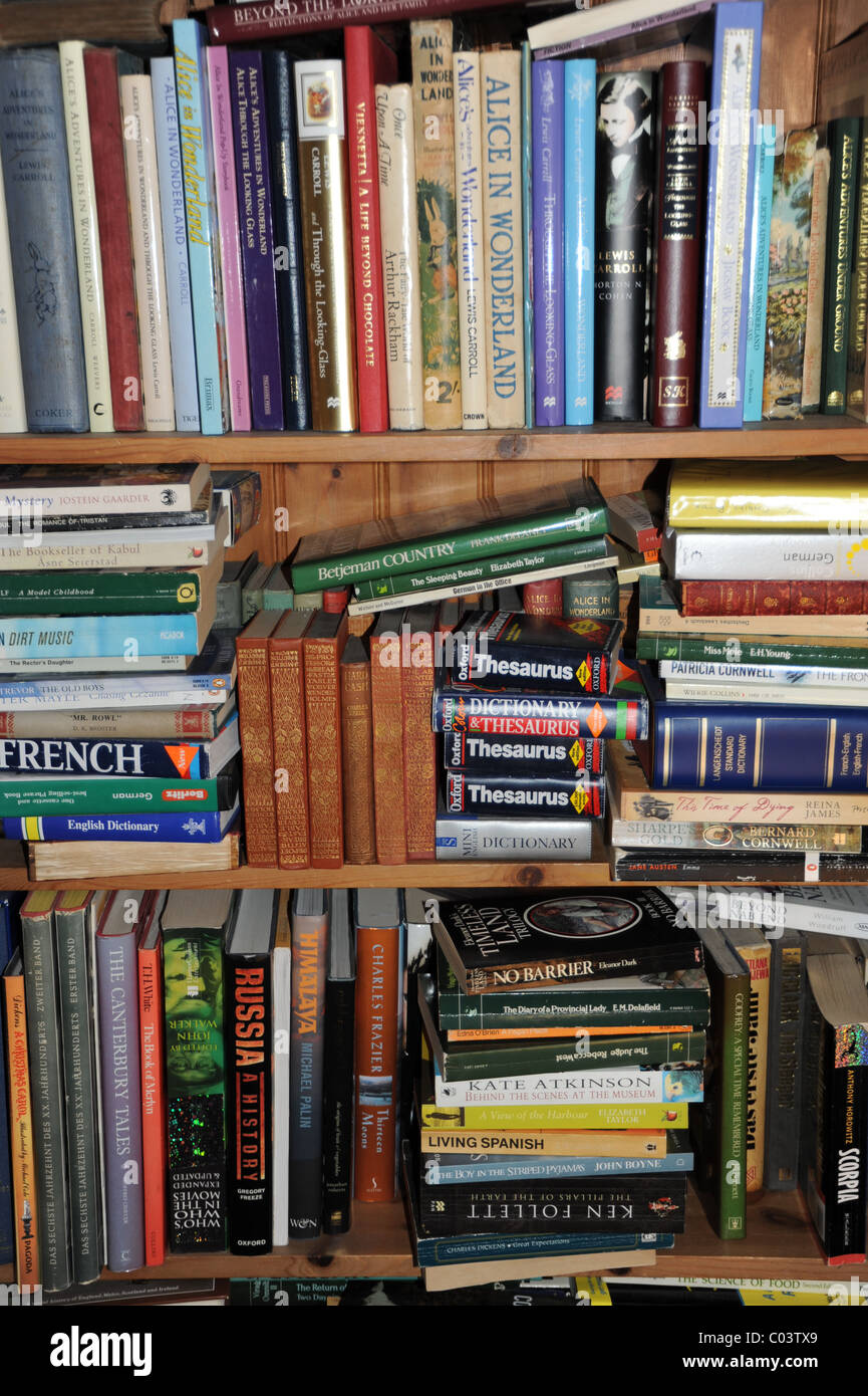 books in bookcase with many alice in wonderland Stock Photo - Alamy