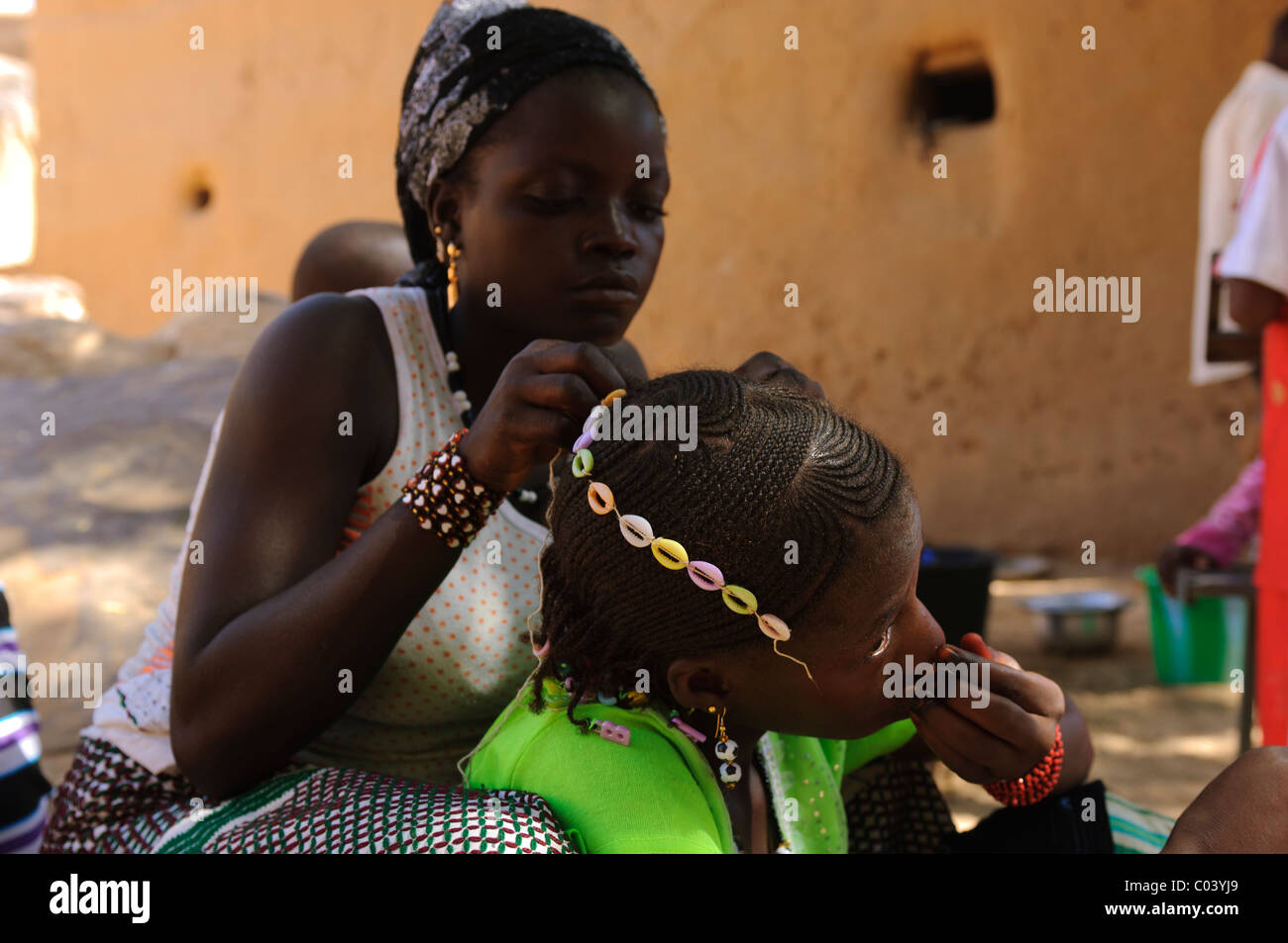 Teenage girls adorning each others hair for the Muslim festival of ...