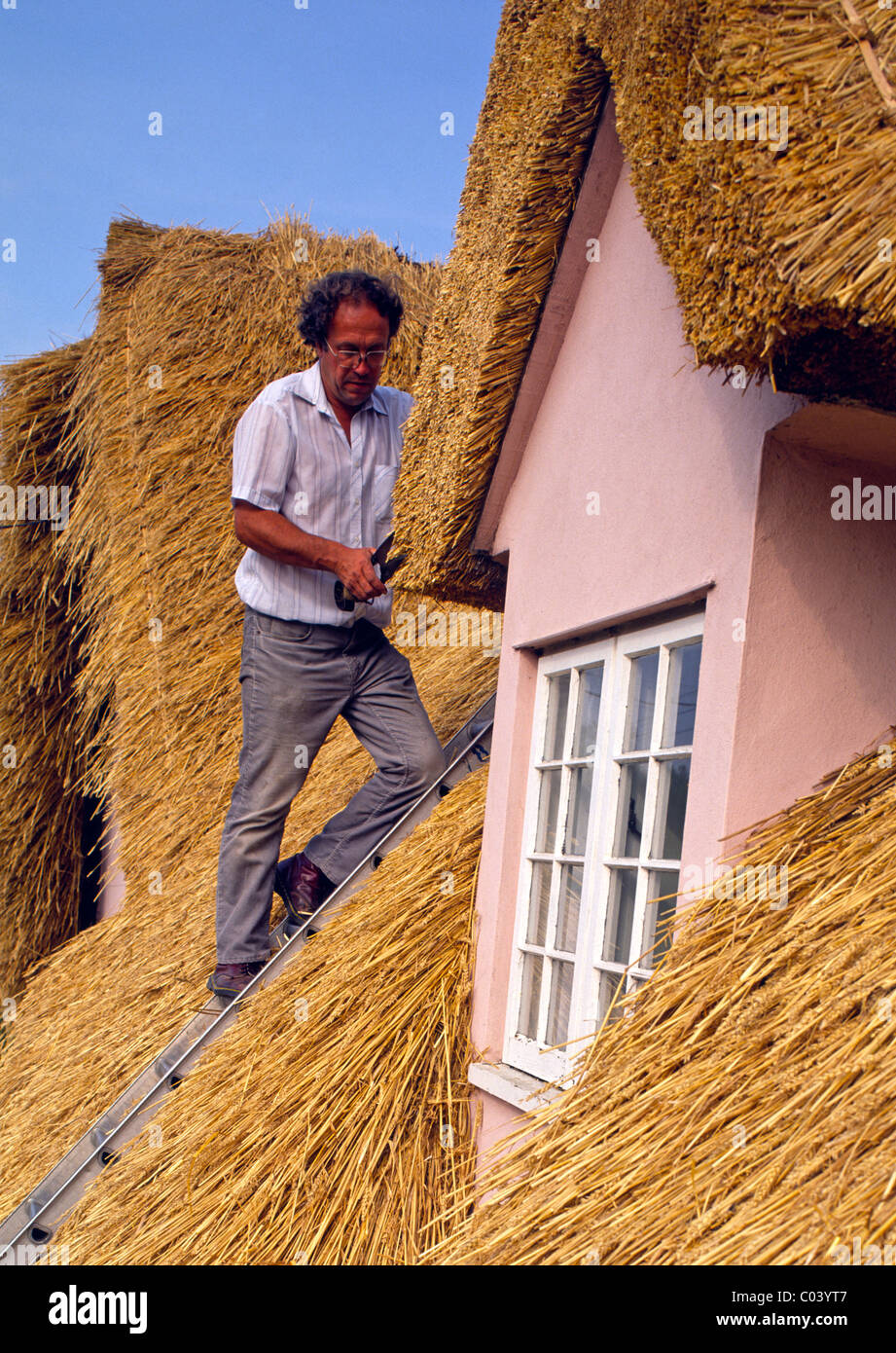 England, Oxfordshire, man thatching roof Stock Photo - Alamy